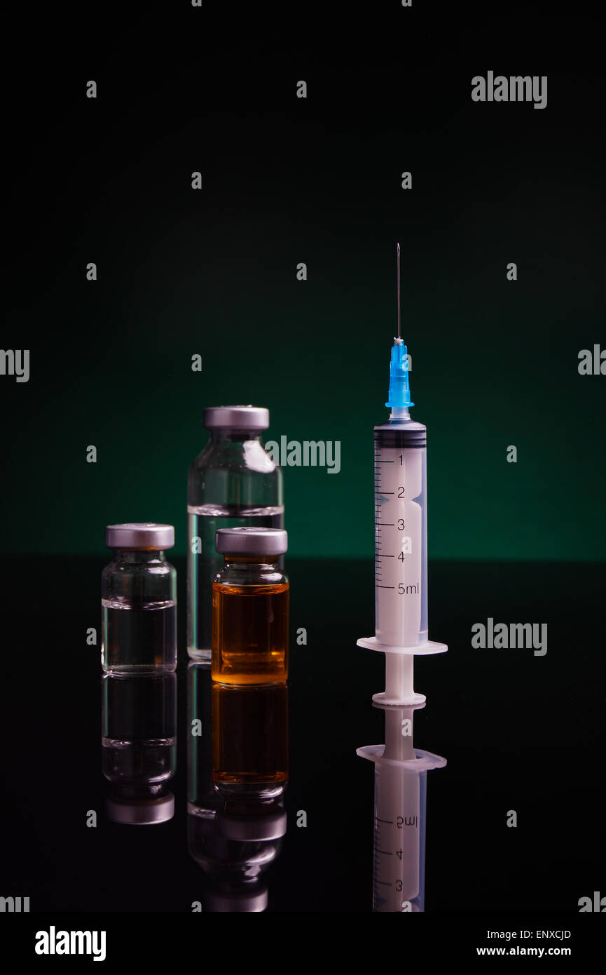Syringe and medical vials with green backlight Stock Photo - Alamy