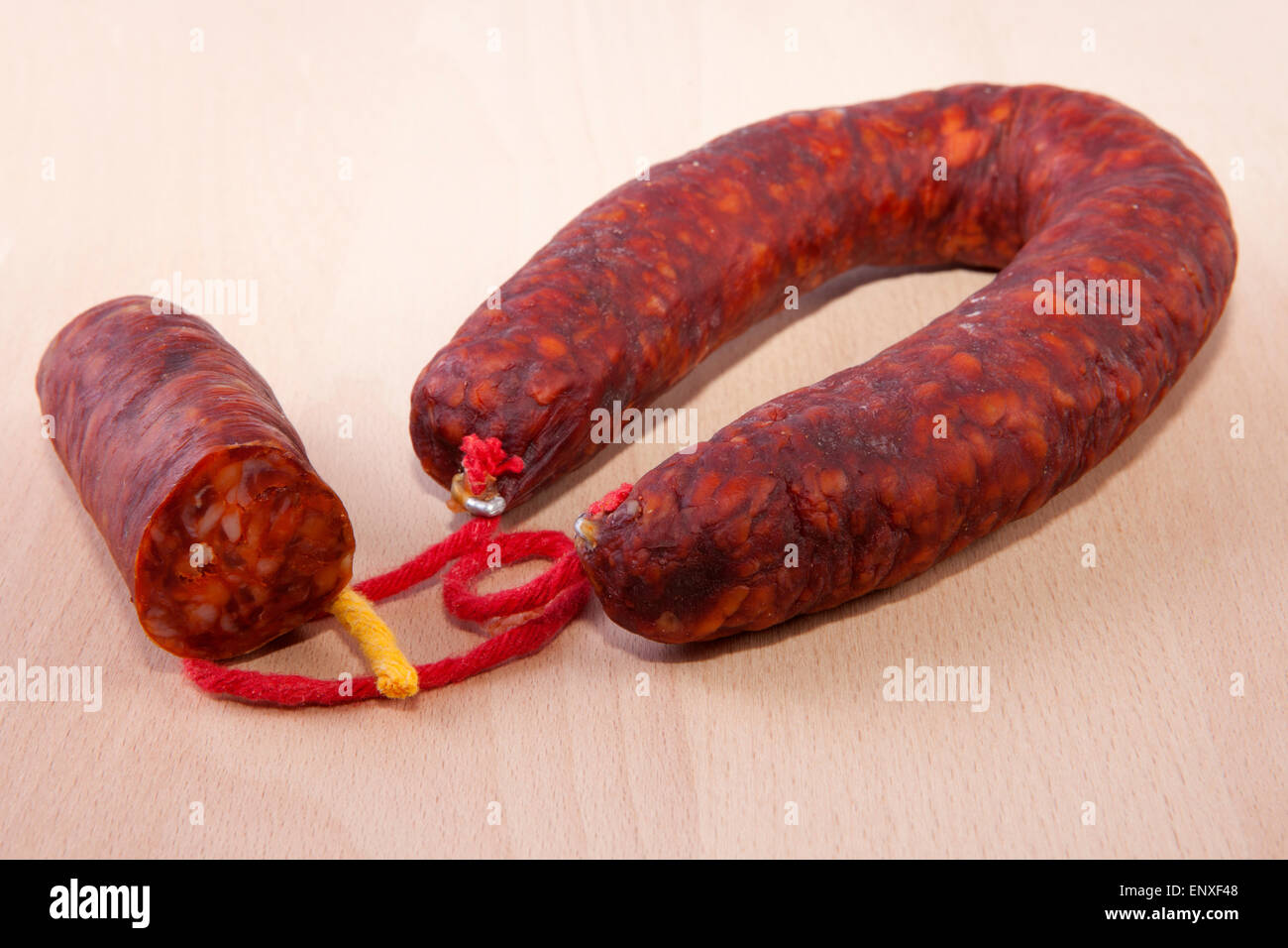 Red iberian chorizo with some cut pieces over wooden. Isolated over ...