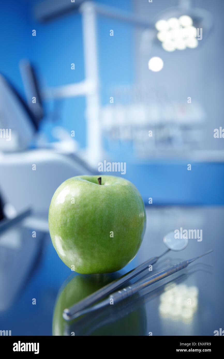 Apple and dental instruments in the foreground Stock Photo - Alamy