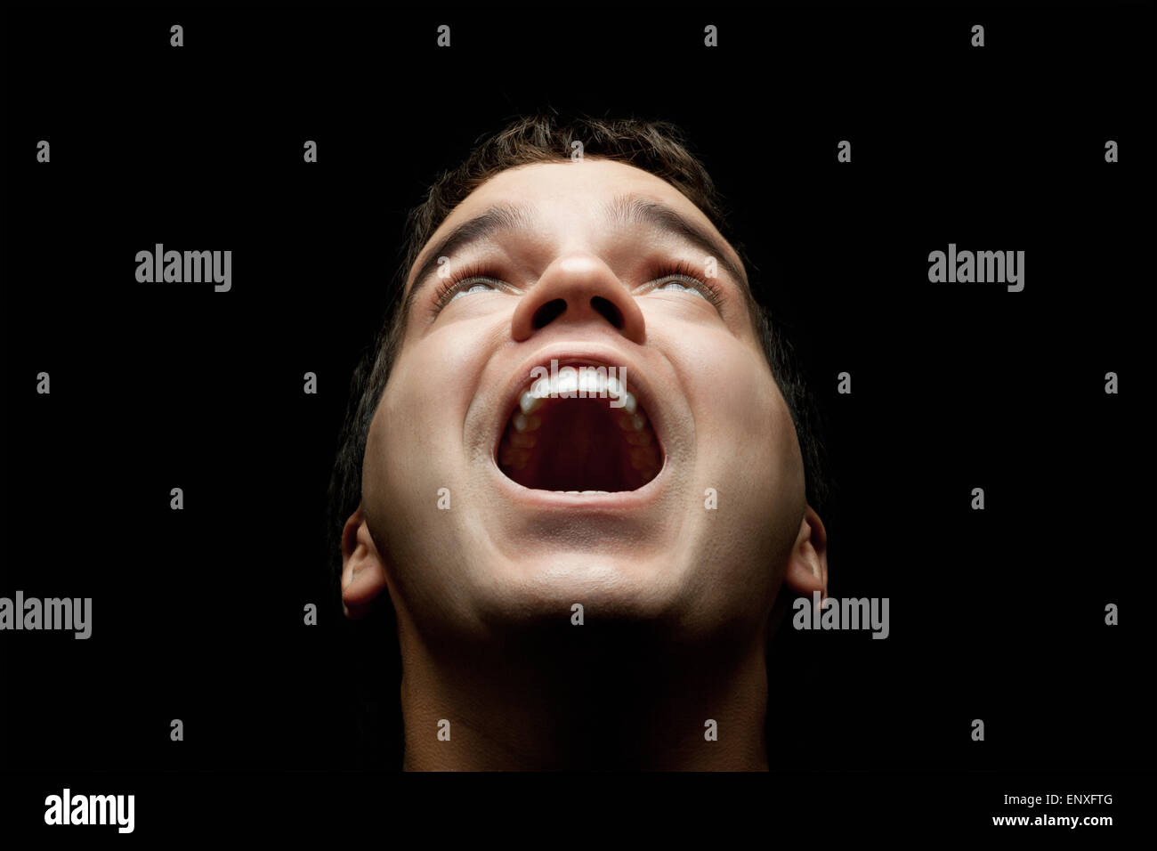 portrait of young man looking up isolated on black Stock Photo - Alamy