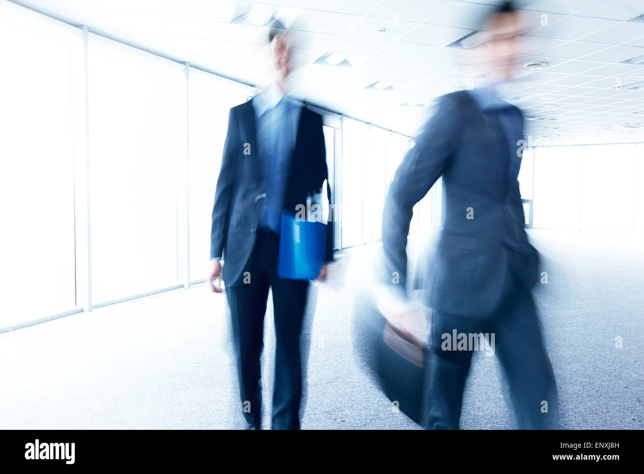 business men walking through office blurred Stock Photo - Alamy