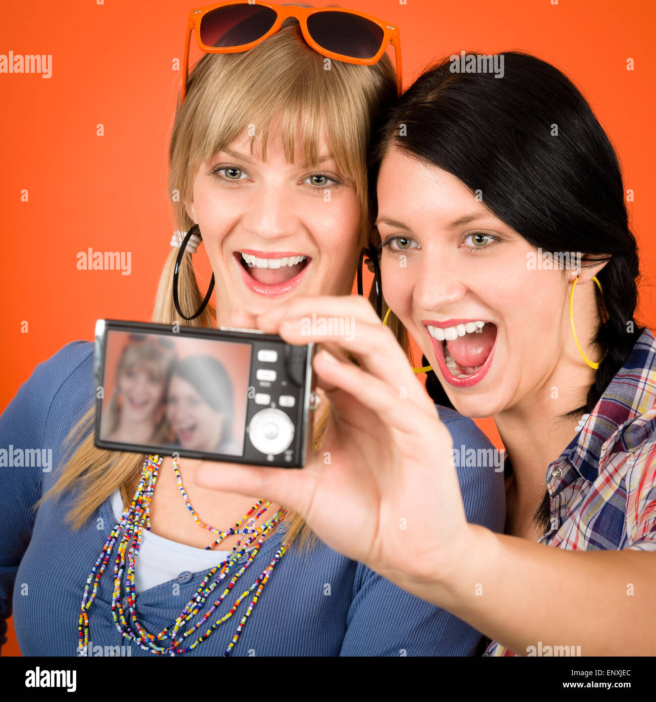 Two young woman friends taking picture smiling Stock Photo - Alamy