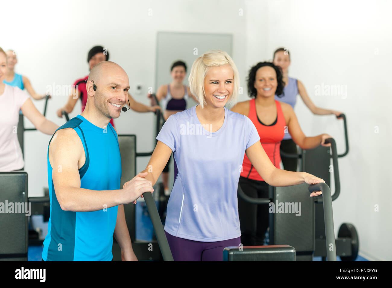 Fitness instructor leading gym people exercise Stock Photo - Alamy