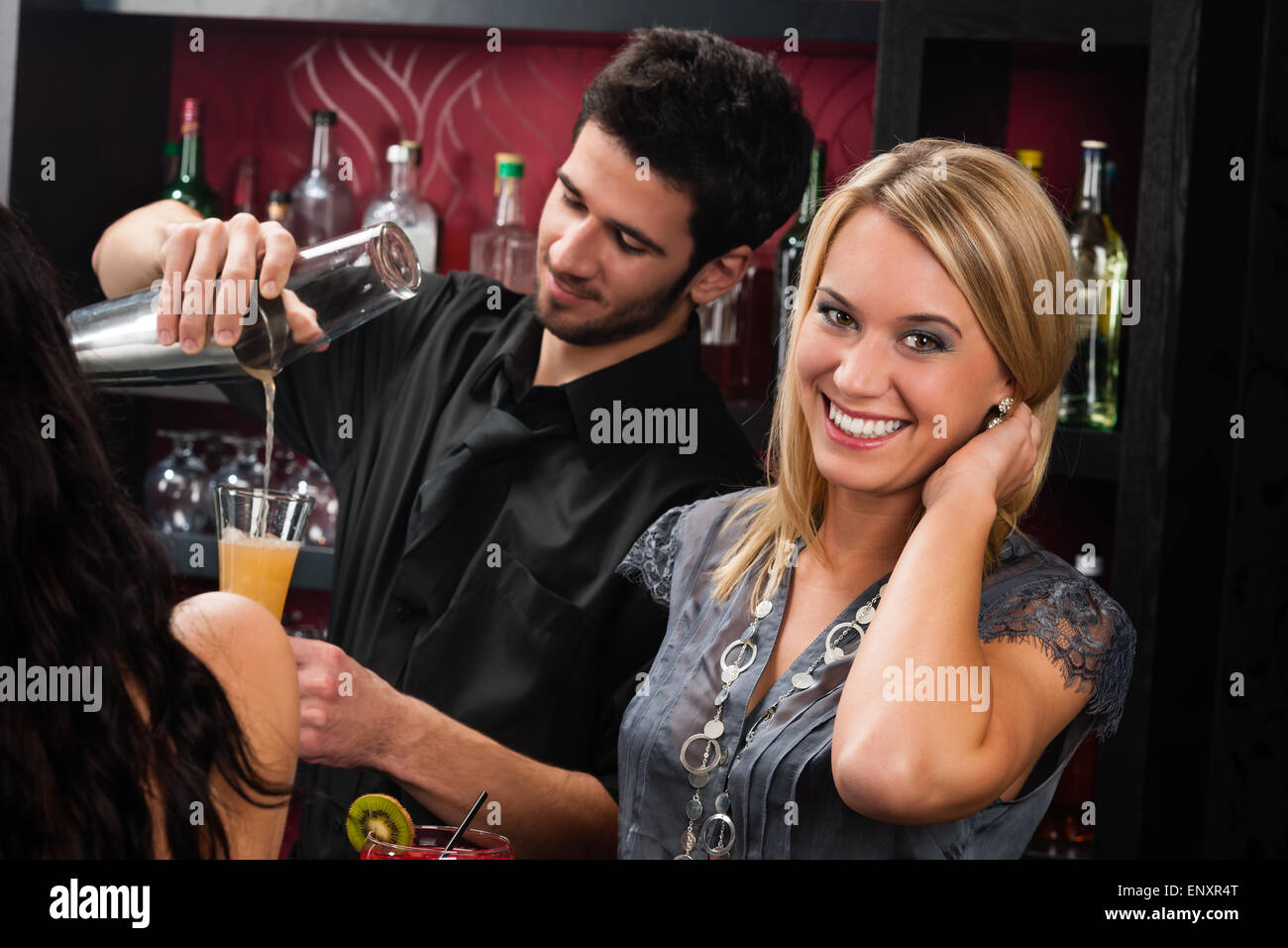 Attractive blond girl at cocktail bar smiling Stock Photo - Alamy