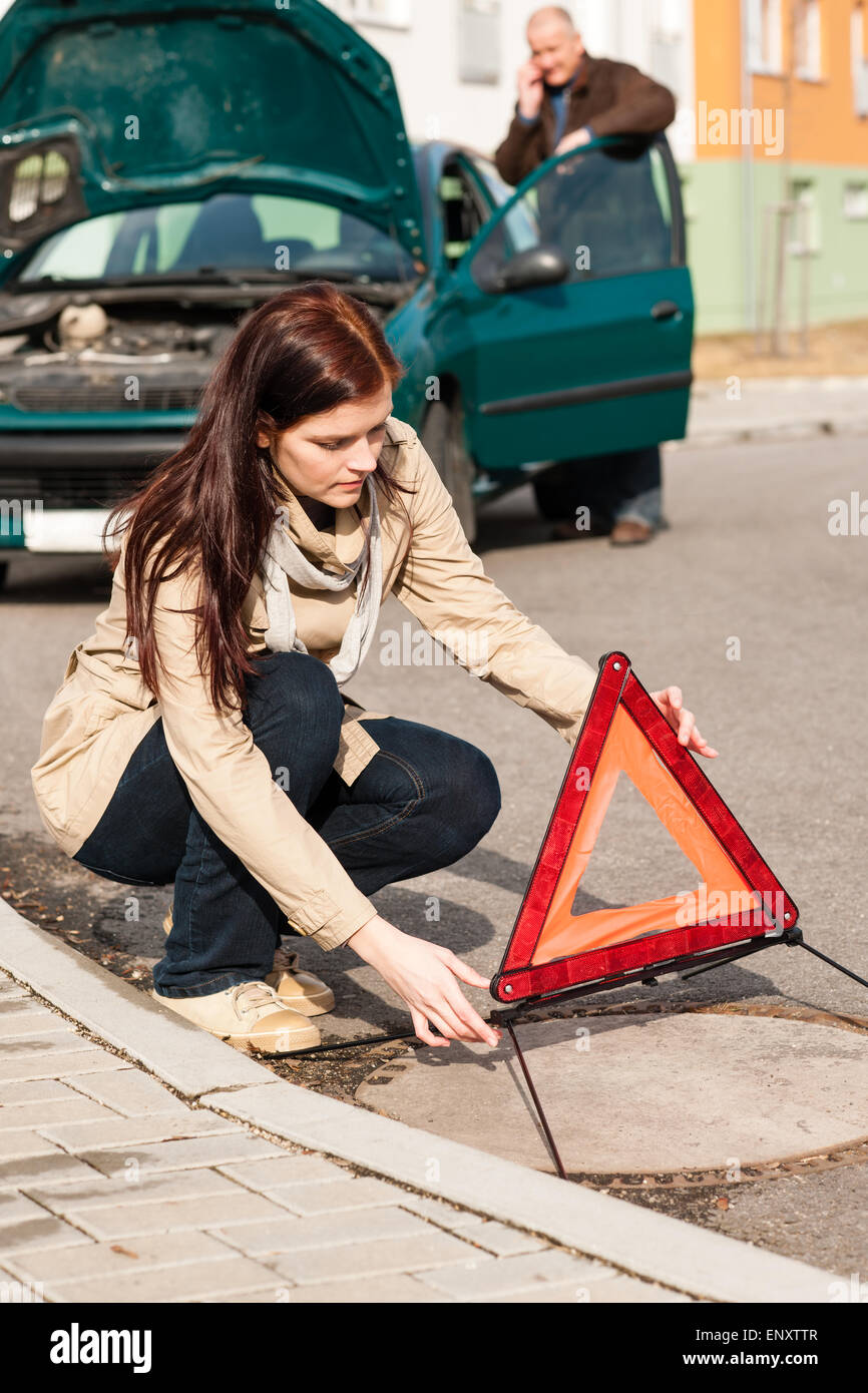 Woman putting triangle sign for car breakdown Stock Photo - Alamy