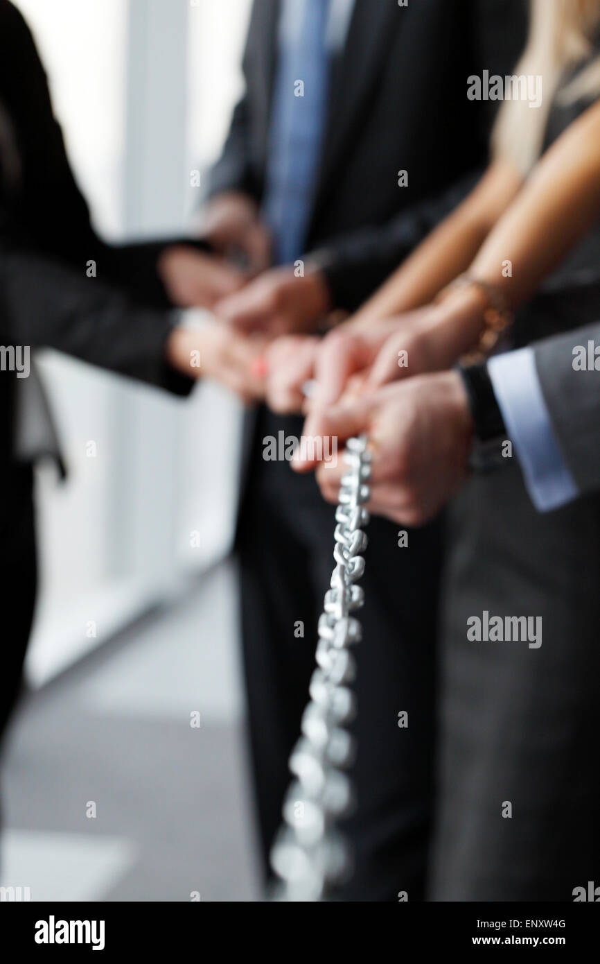 team pulling steel chain together Stock Photo - Alamy