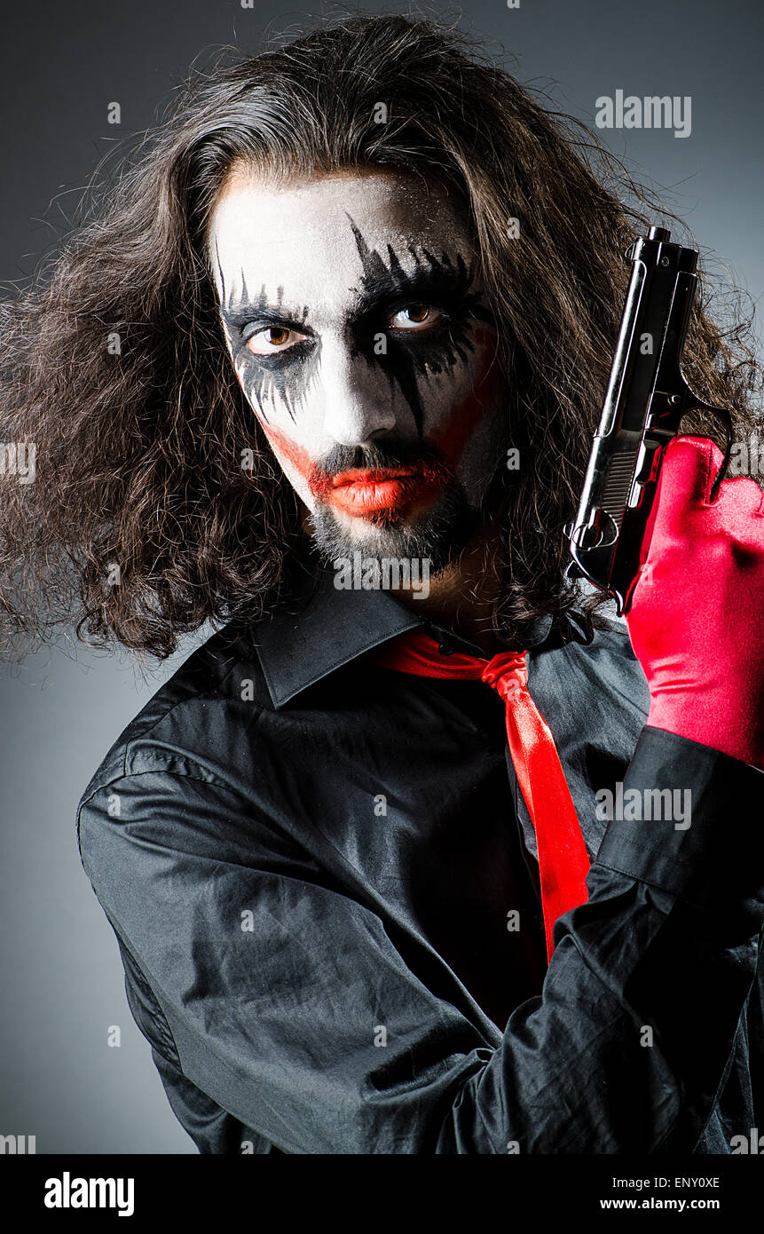 Evil clown with gun in dark room Stock Photo - Alamy