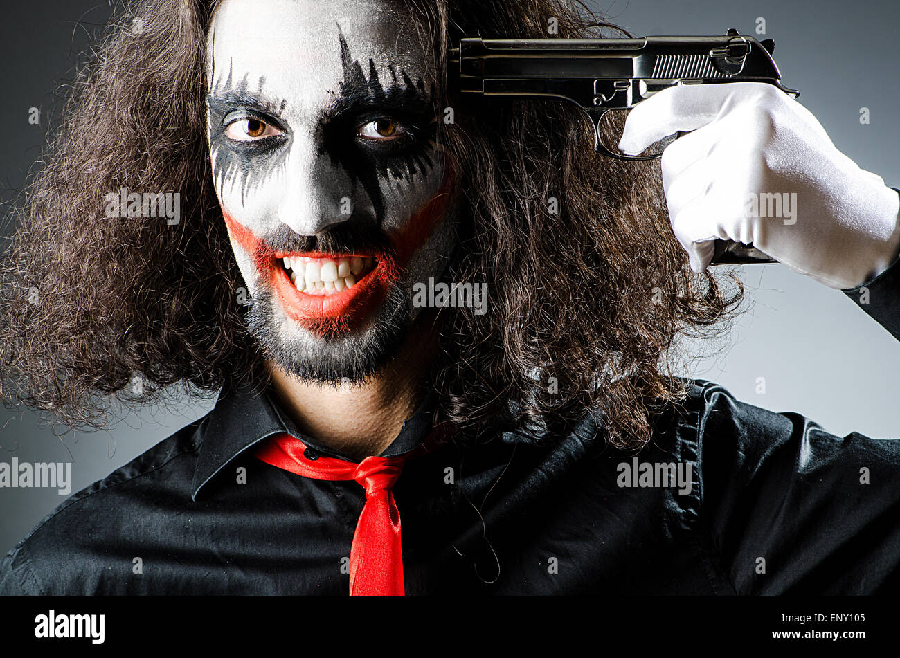 Evil clown with gun in dark room Stock Photo - Alamy