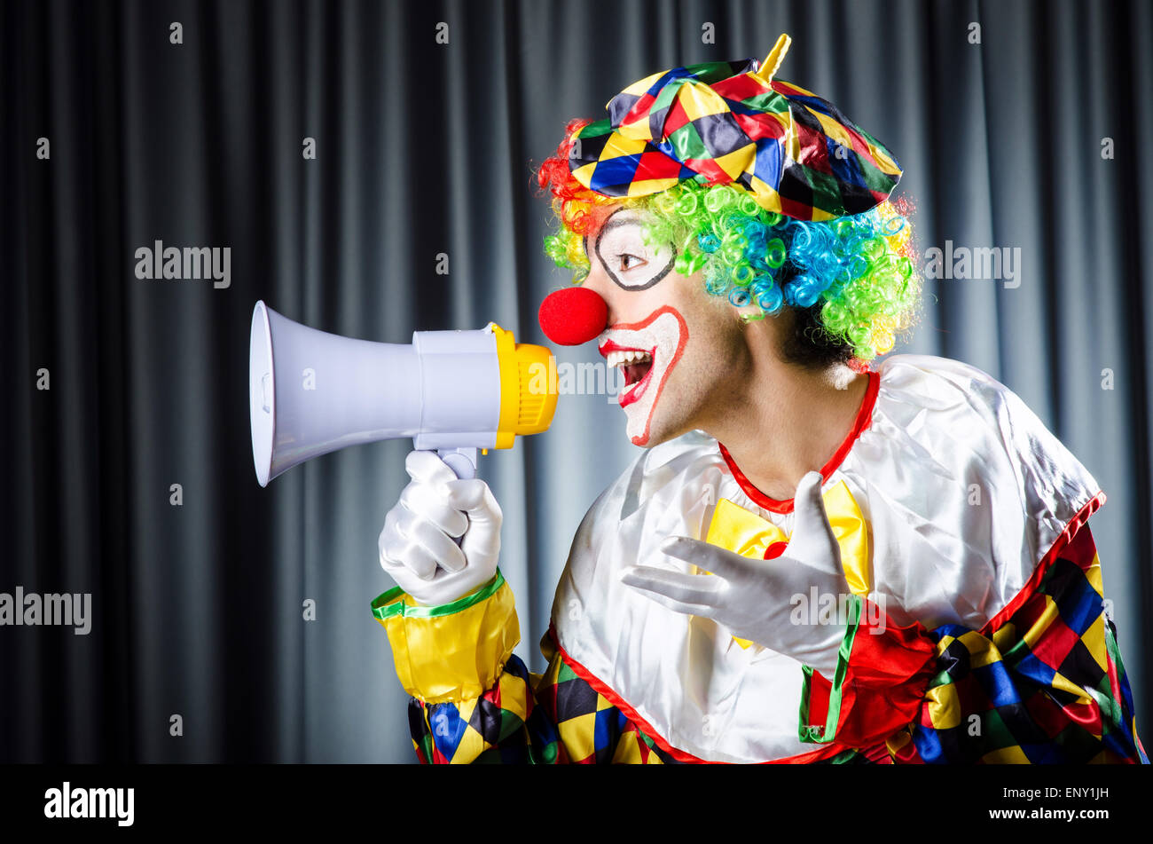 Clown in studio with loudspeaker Stock Photo - Alamy