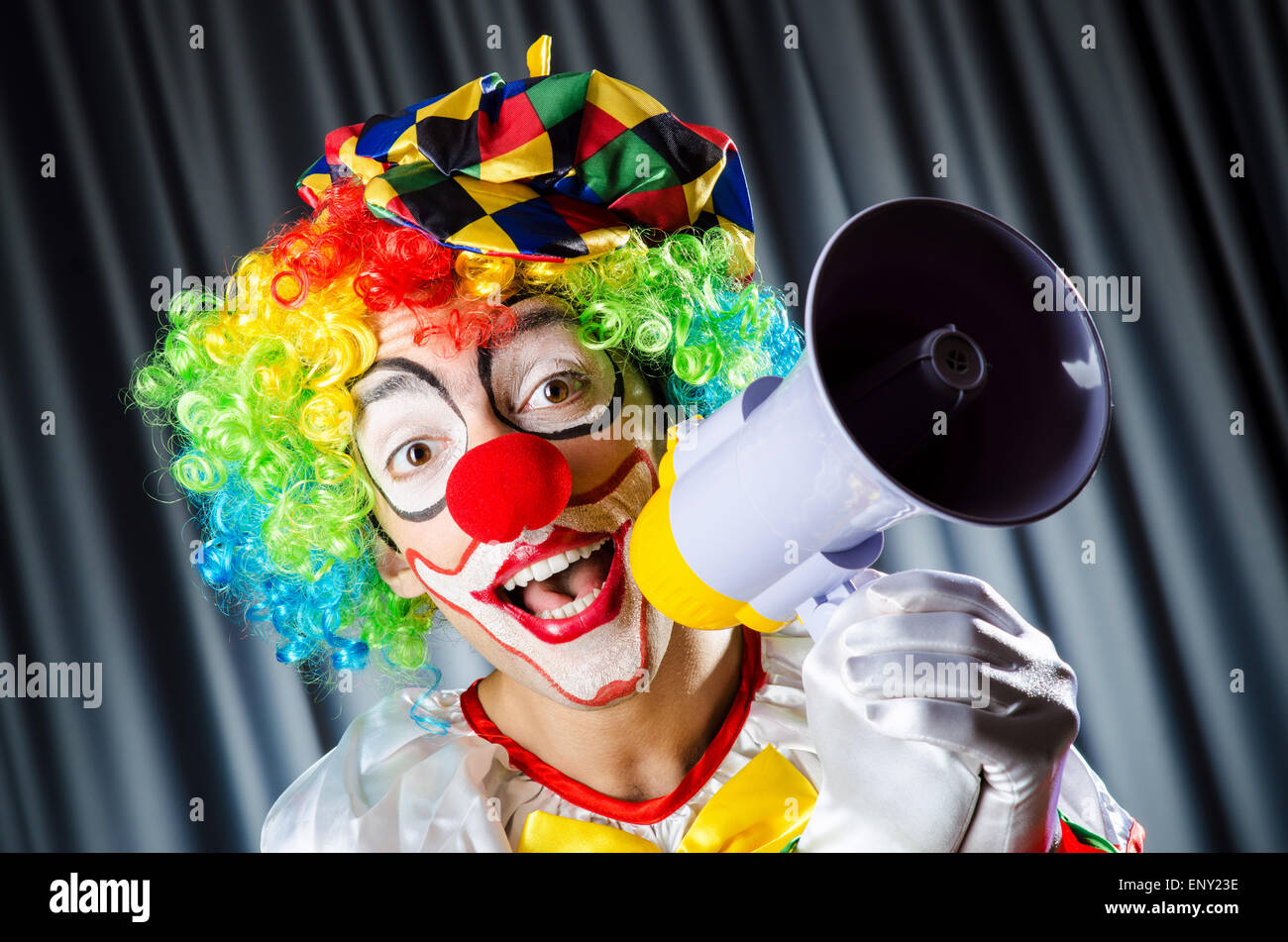 Clown in studio with loudspeaker Stock Photo - Alamy