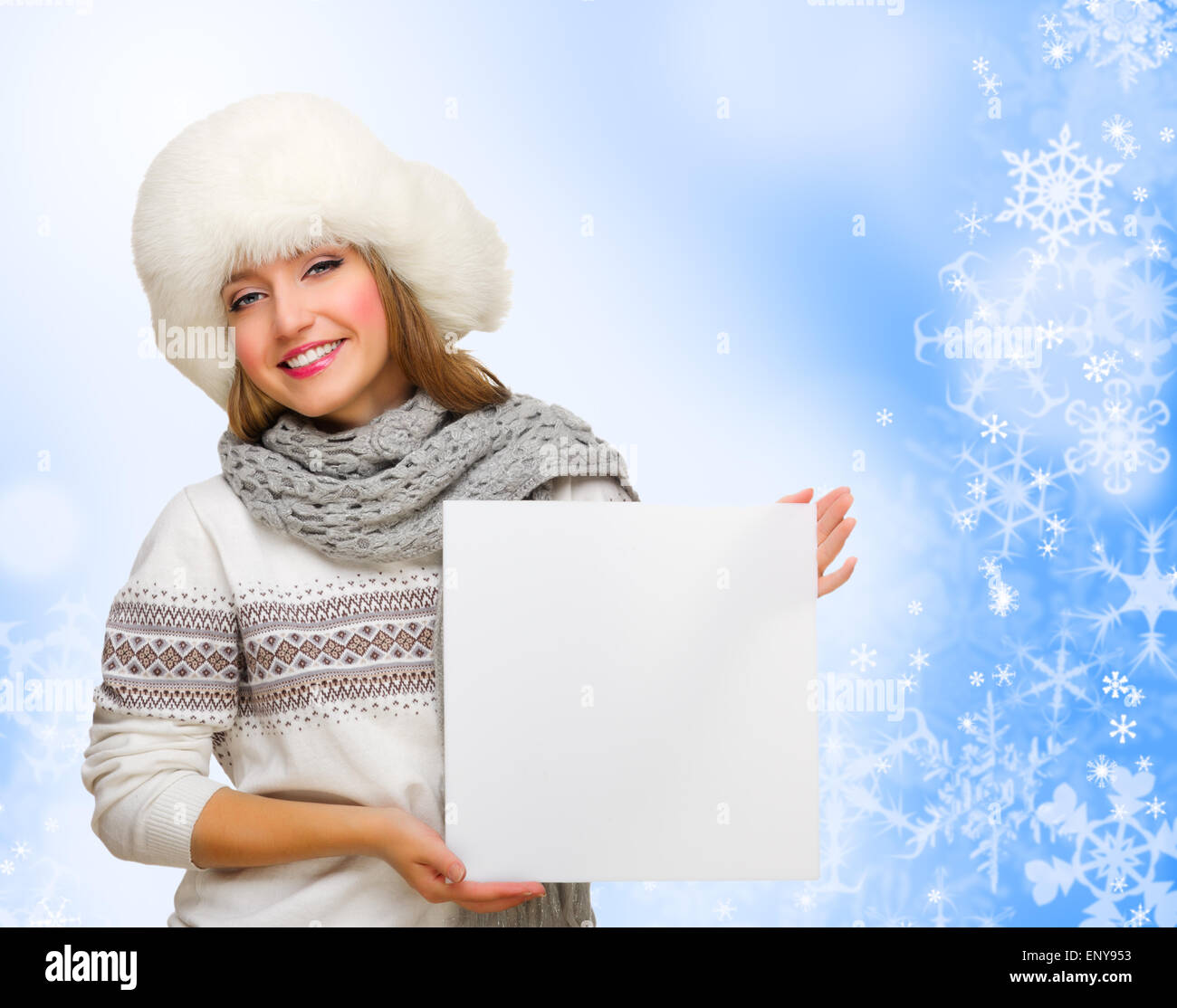 Young girl with empty card on blue winter background Stock Photo - Alamy