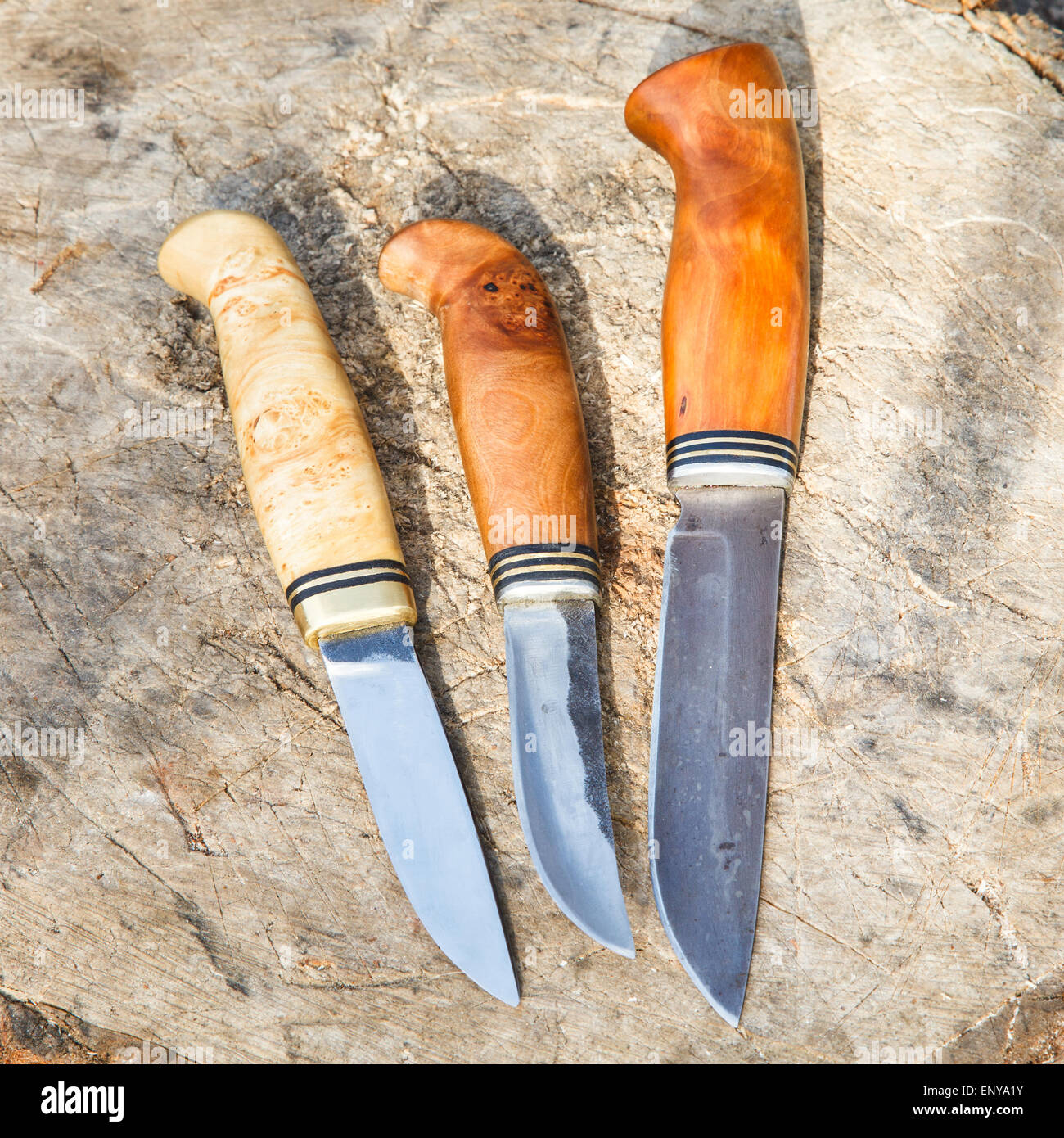 three hand made knives on tree stump Stock Photo - Alamy
