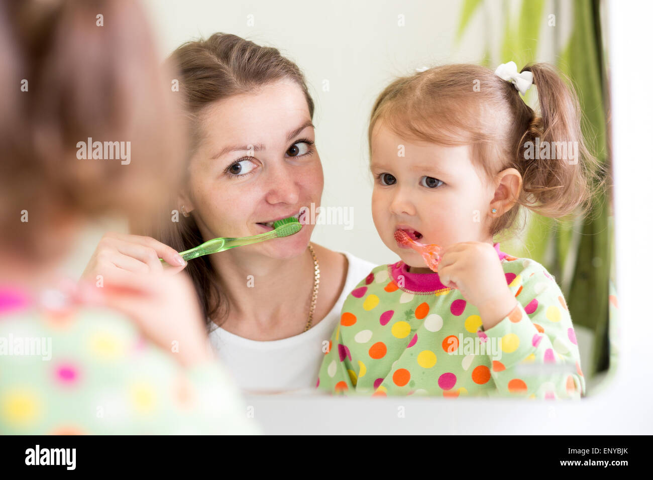 Woman teaching child daughter teeth brushing in bathroom Stock Photo ...