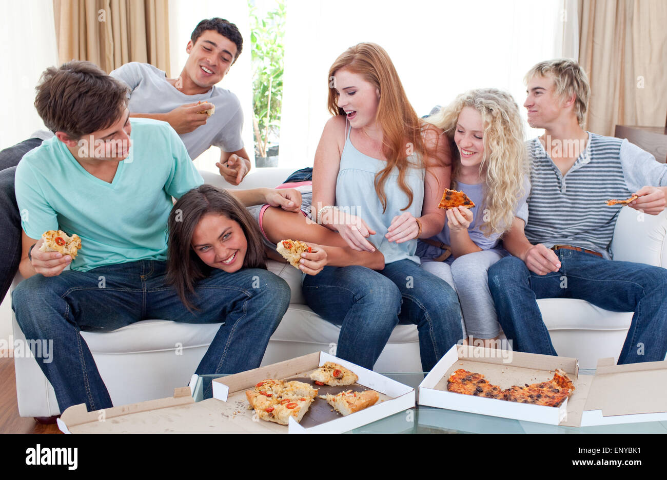 Adolescents eating pizza at home Stock Photo - Alamy