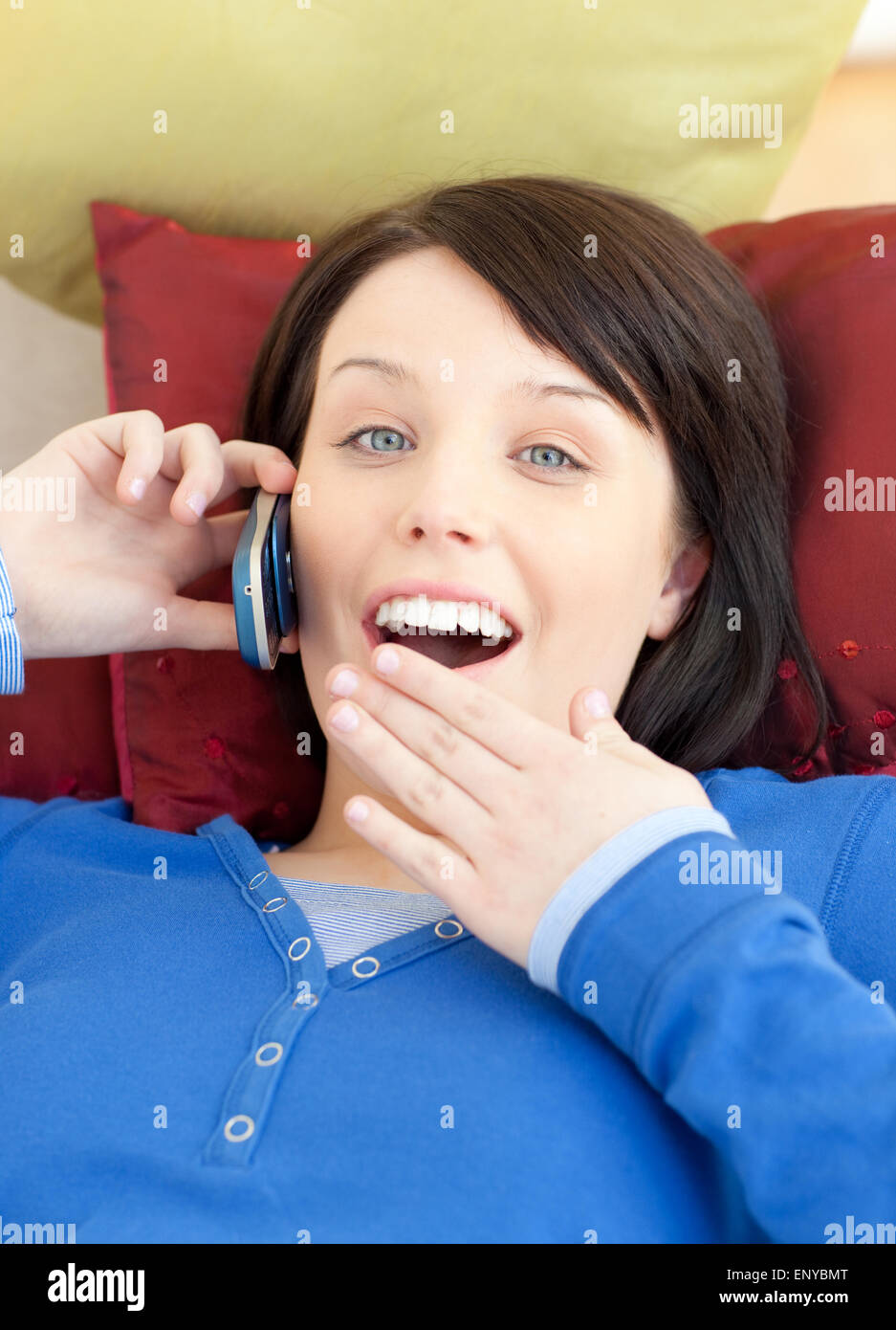 Astonished teen girl talking on phone lying on a sofa Stock Photo - Alamy