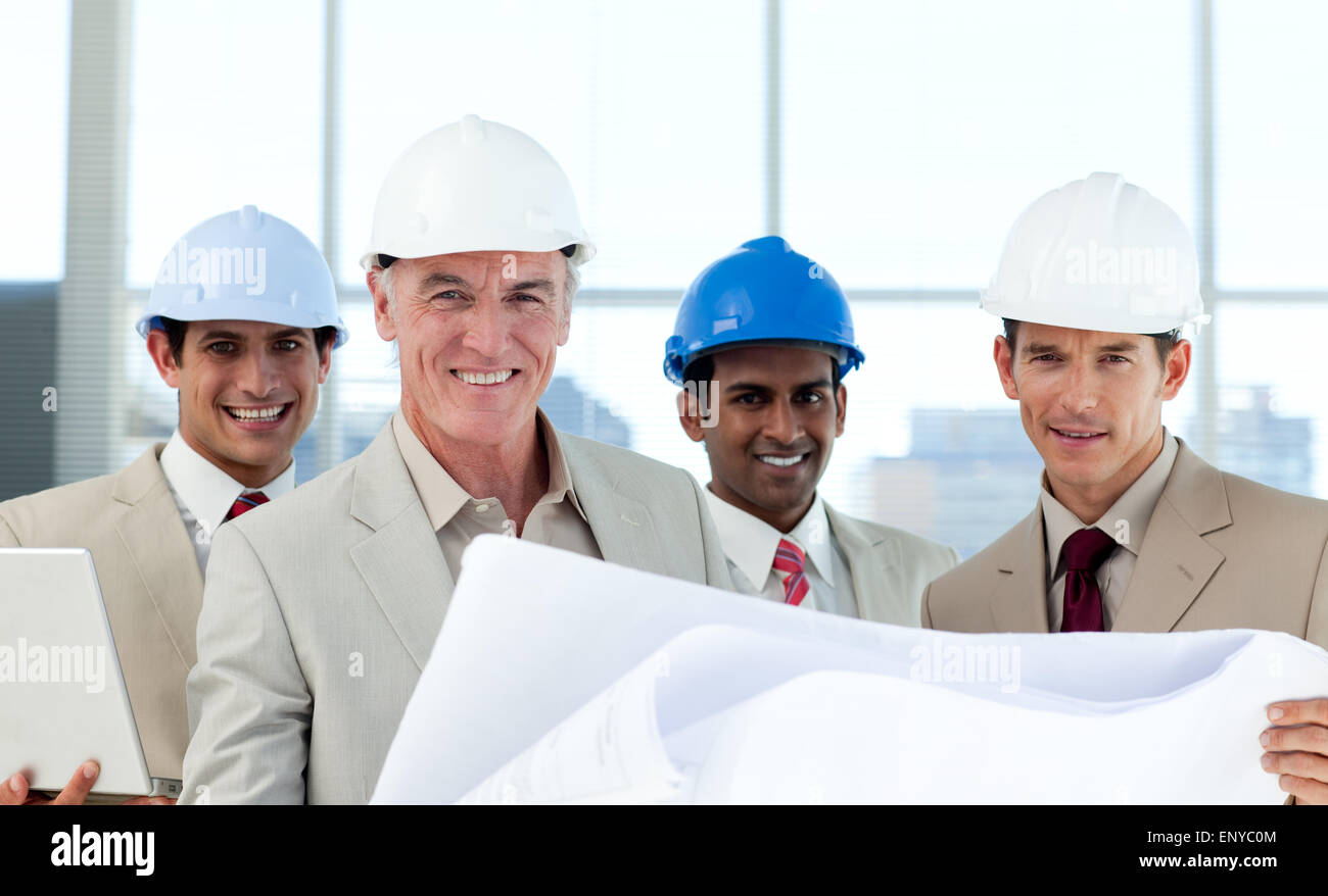 Smiling group of architect examining blueprints Stock Photo - Alamy