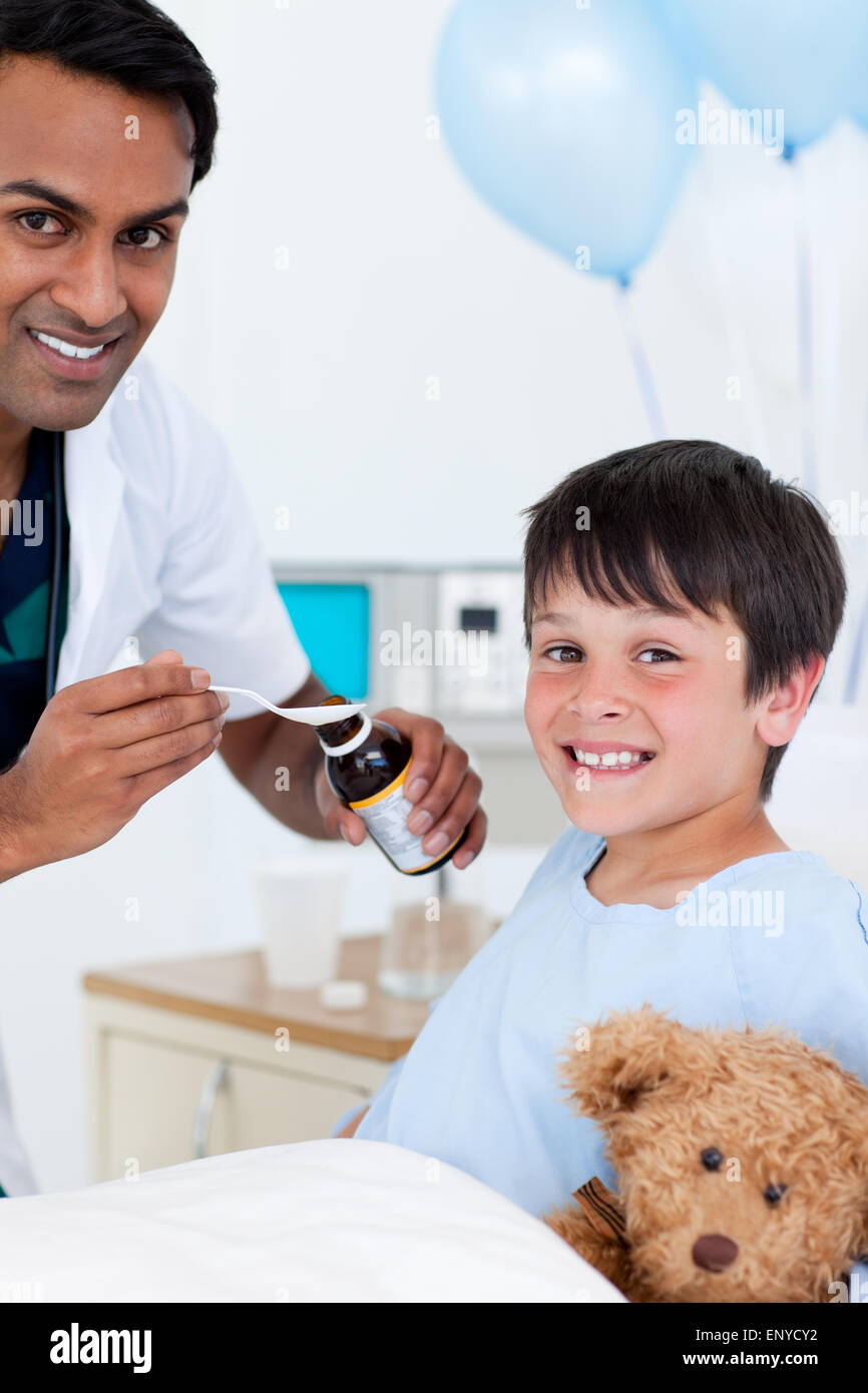 Smiling doctor examining a little boy with his father Stock Photo - Alamy