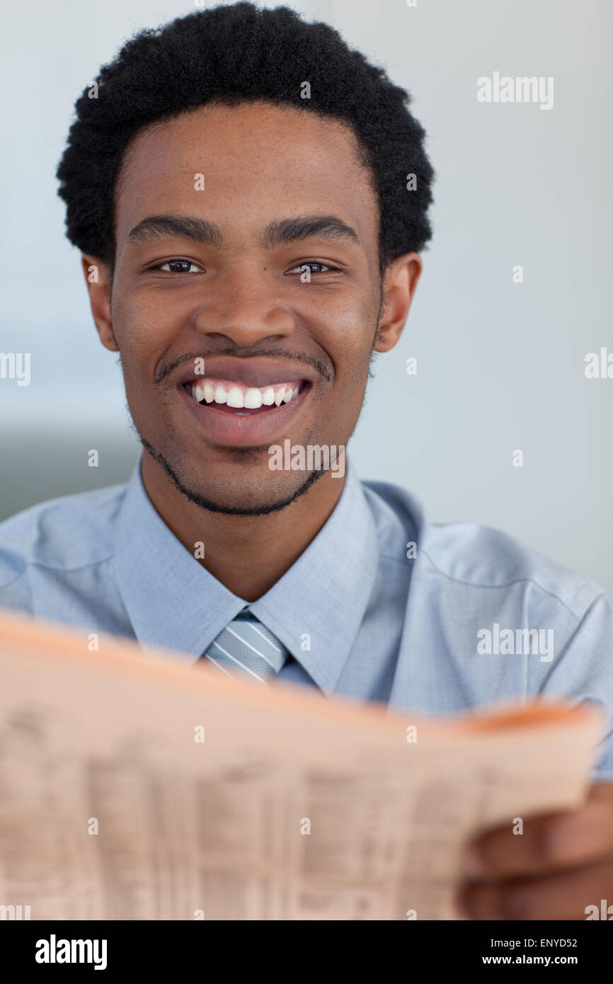Afro-American businessman with a newspaper smiling at the camera Stock ...