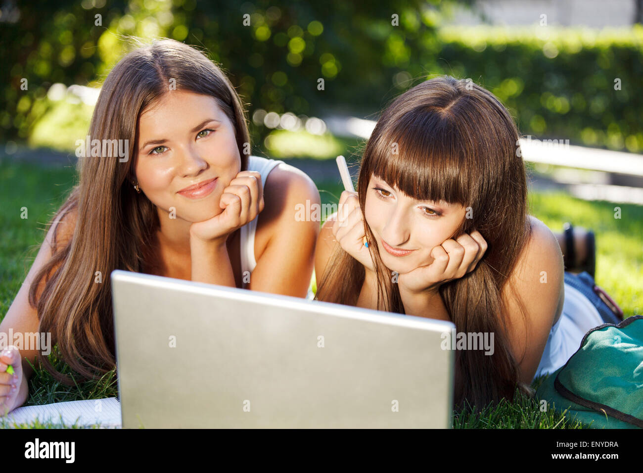 Happy young student girls using a computer outdoors Stock Photo - Alamy