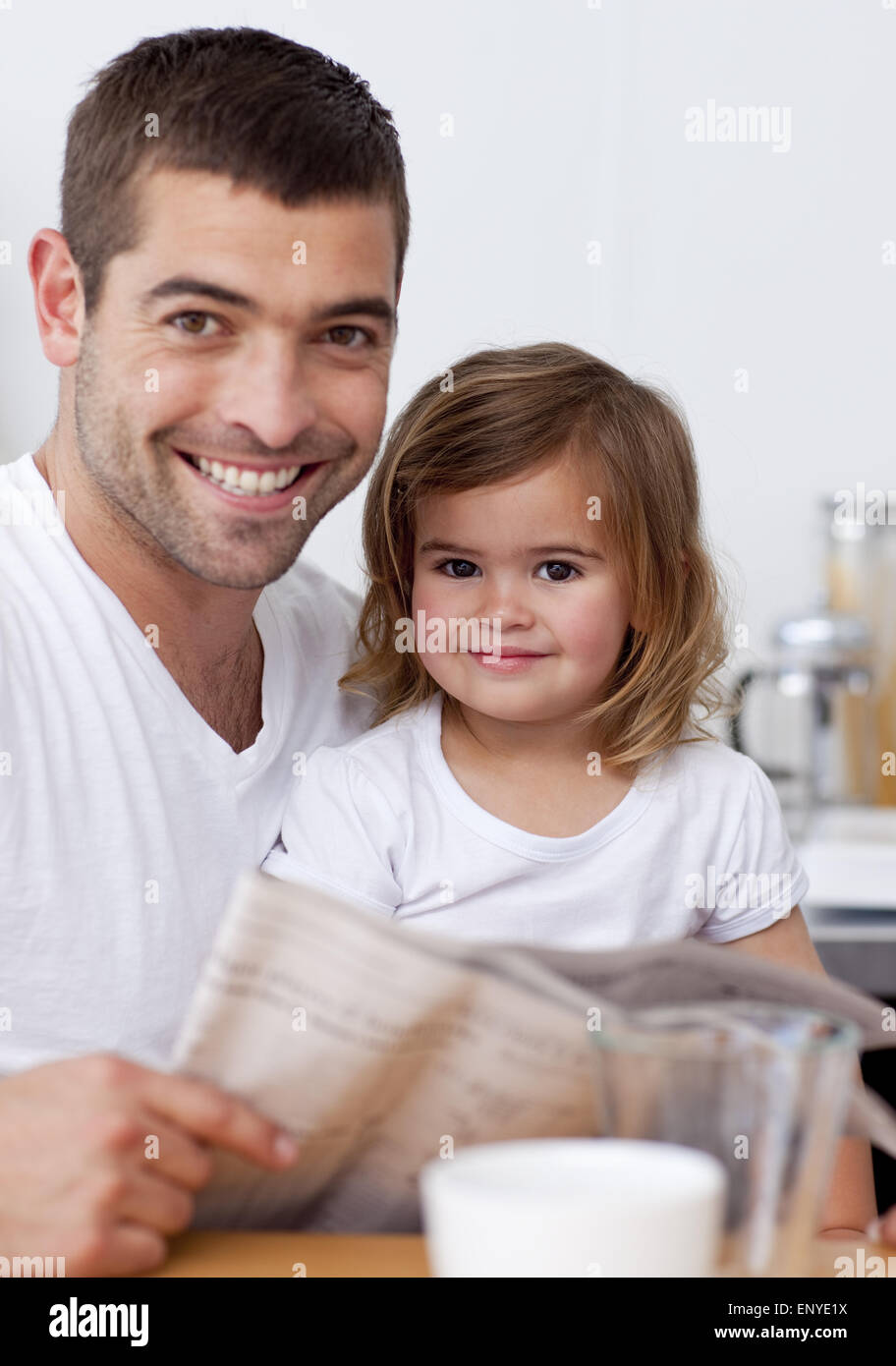 Smiling father reading a newspaper with his daughter Stock Photo - Alamy
