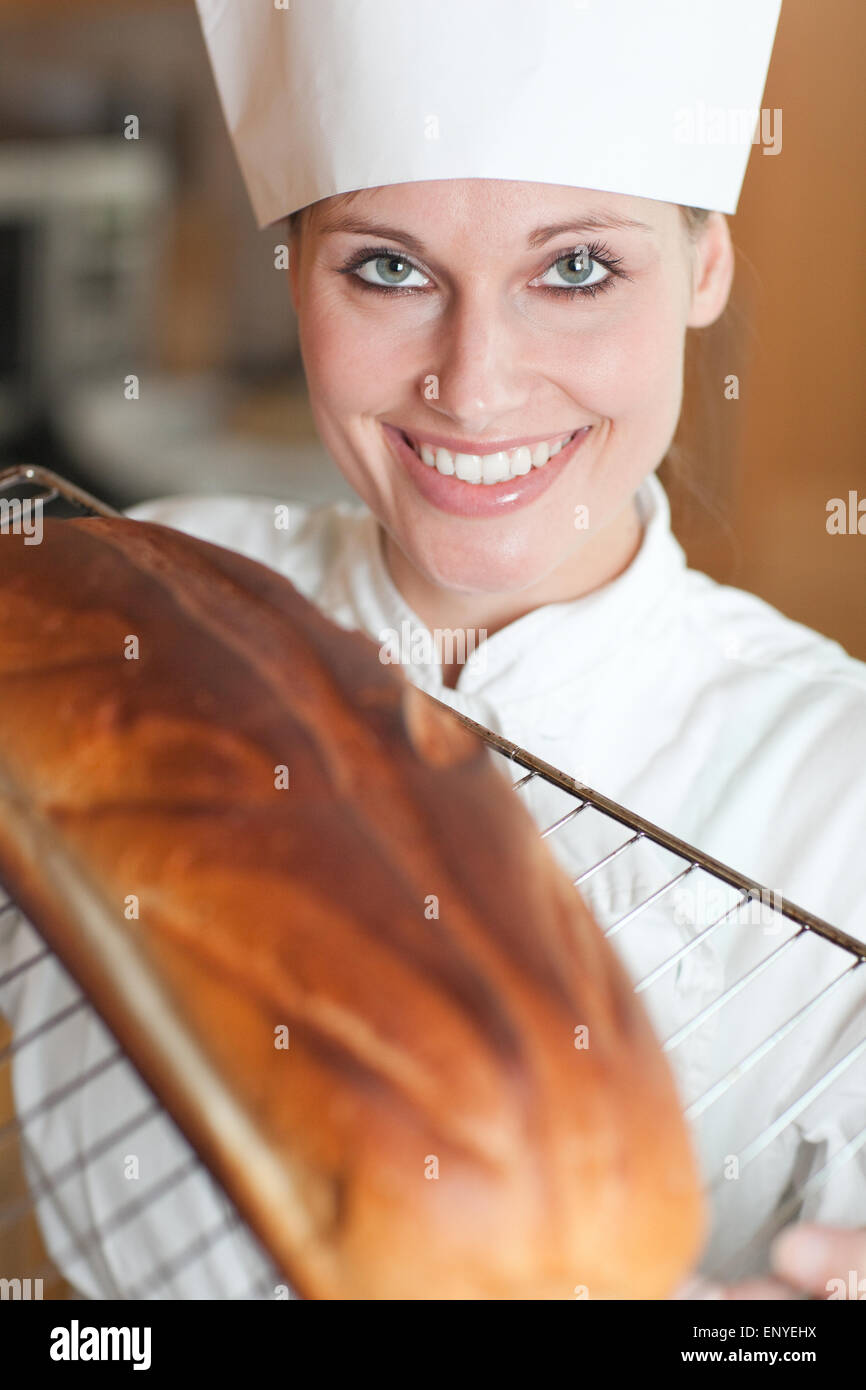 Smiling female chef baking bread Stock Photo - Alamy