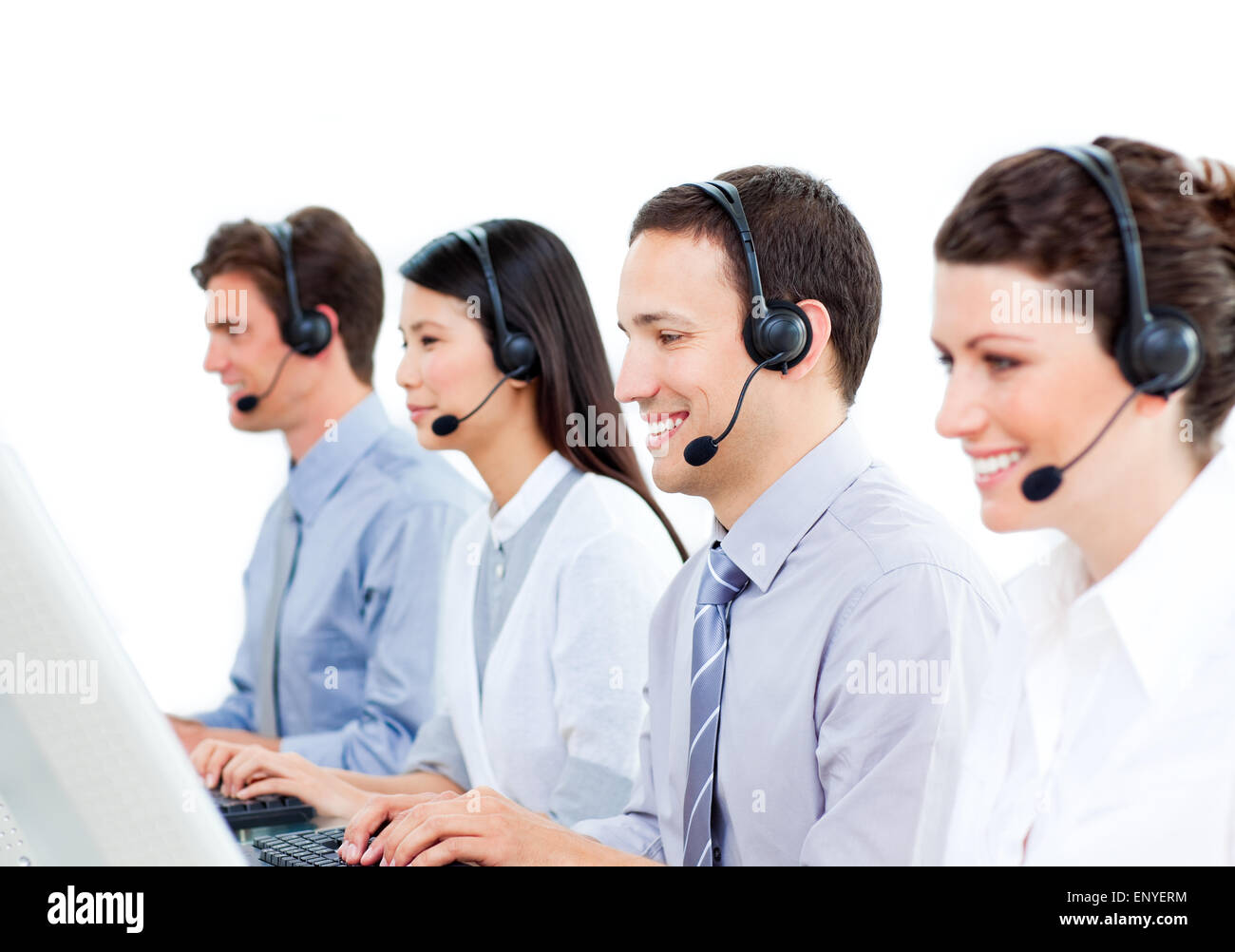 Smiling customer service agents working in a call center against a ...