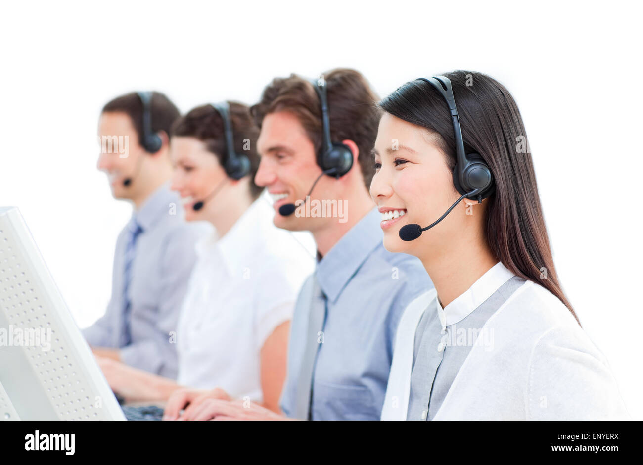 Cheerful customer service agents working in a call center against a ...