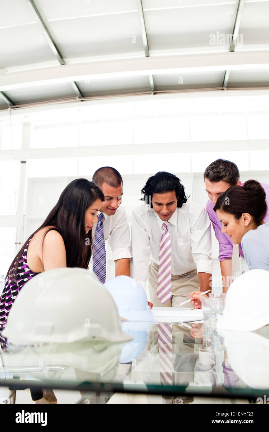 International engineers and their manager discussing blueprints Stock ...