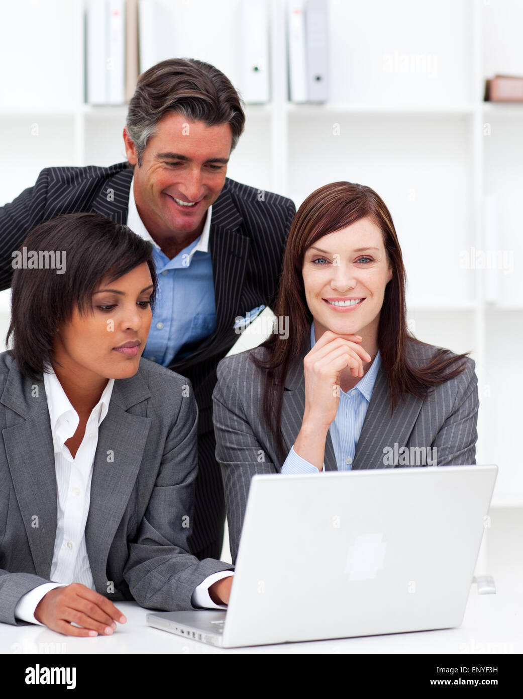 Positive businesswomen and their colleague working at a laptop Stock ...