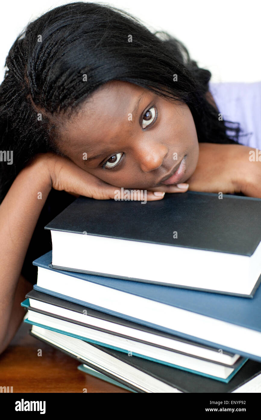 Tired student leaning on a stack of books Stock Photo - Alamy