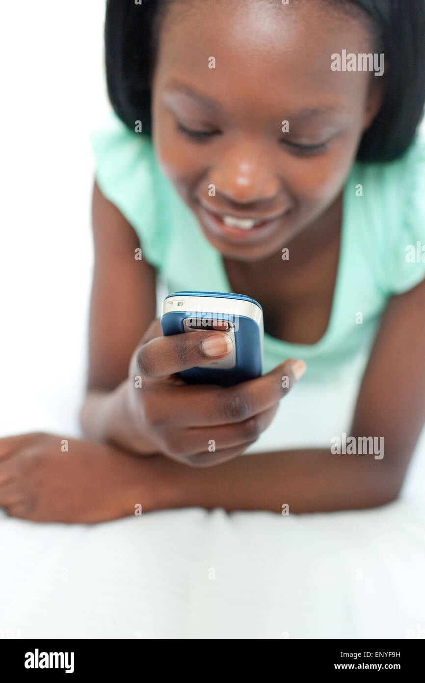Afro-American teen girl using a mobile phone lying on her bed Stock ...
