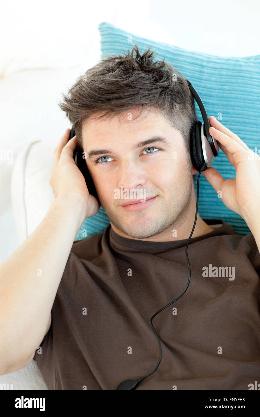Smiling young man with headphones listening to music Stock Photo - Alamy