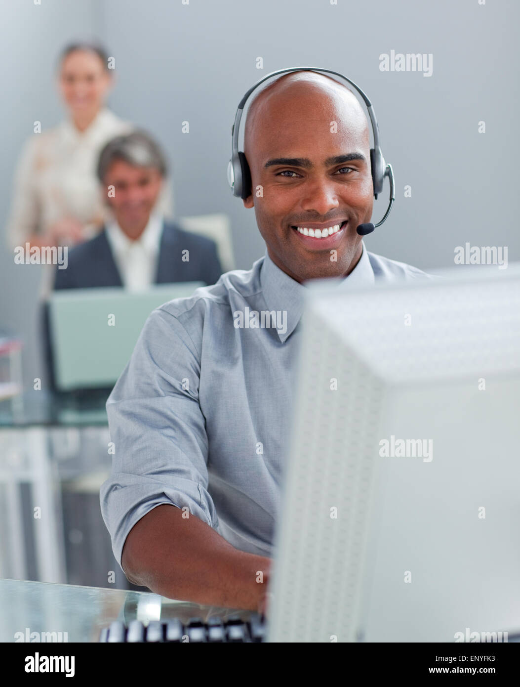 Confident businessman with headset on working at a computer Stock Photo ...