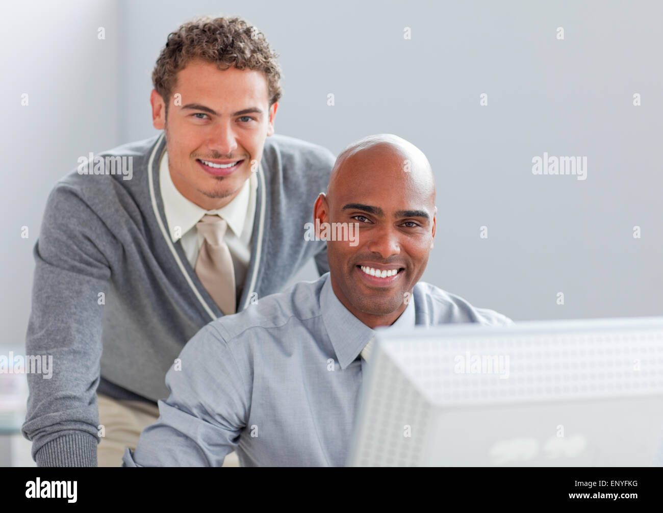 Young businessman helping his colleague at a computer Stock Photo - Alamy