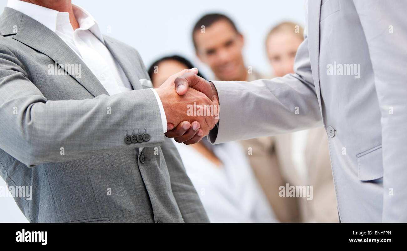 Businessmen shaking hand in front of their colleagues Stock Photo - Alamy