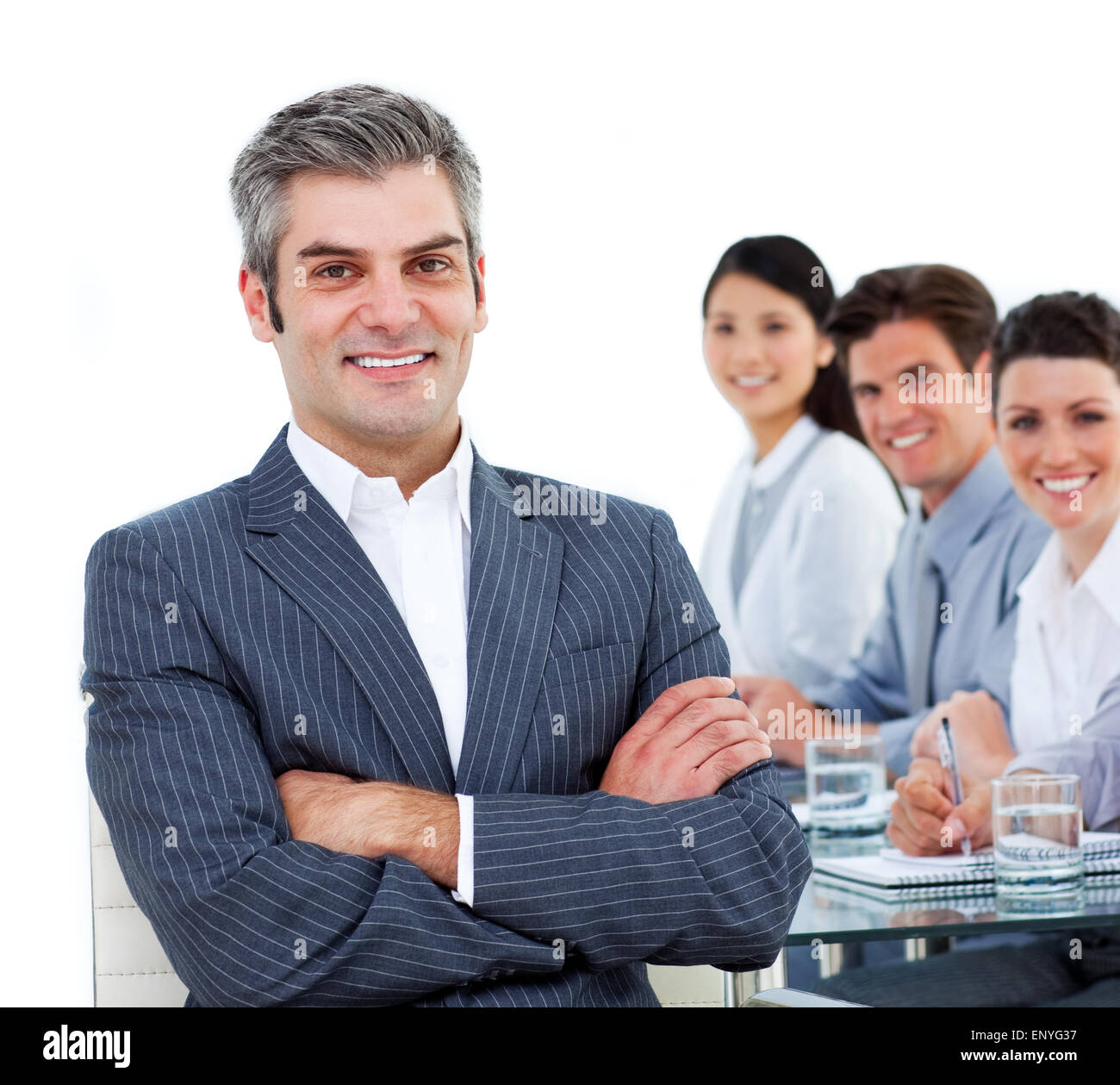 Confident manager sitting in front of his team against a white ...