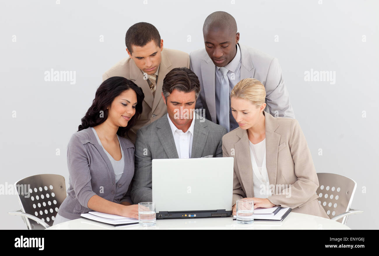 Multi-ethnic business team working with a laptop together Stock Photo ...