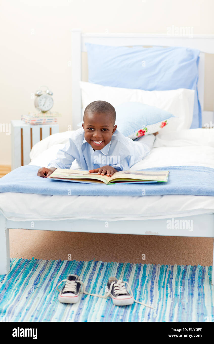 Smiling little boy reading a book Stock Photo - Alamy