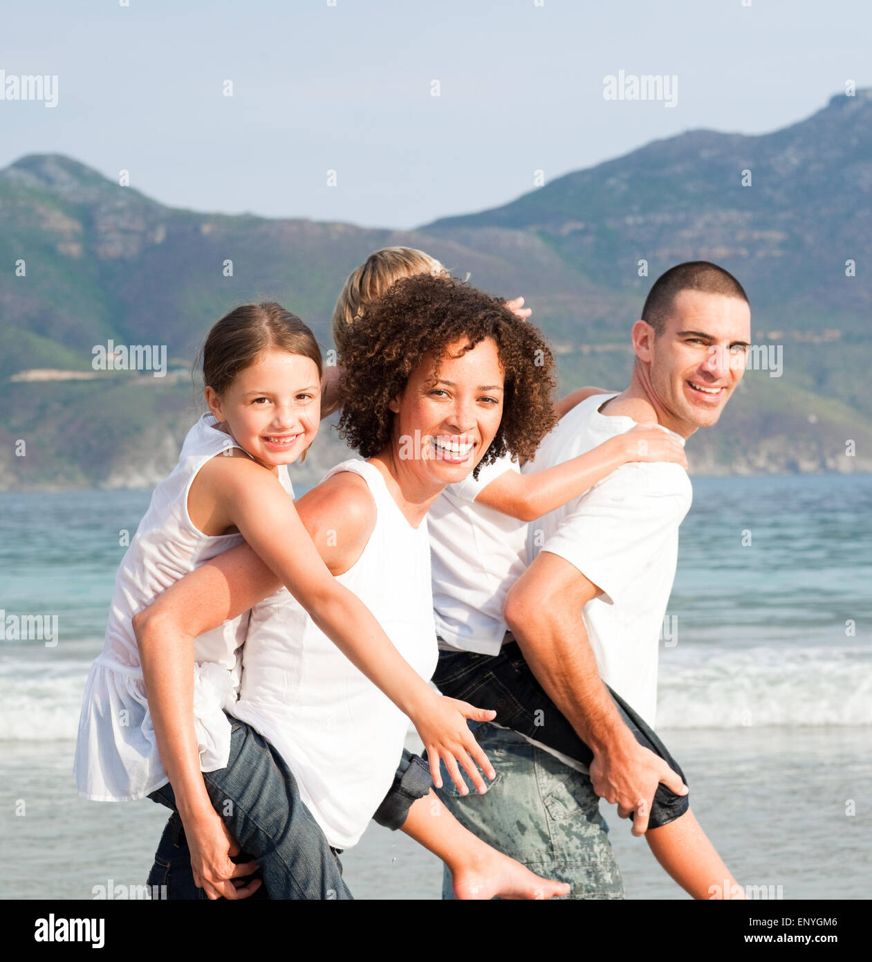 Parents giving two young children piggyback rides Stock Photo - Alamy