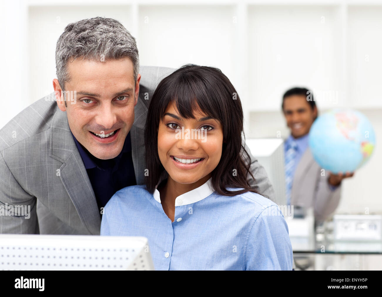 Smiling co-workers working together at a computer Stock Photo - Alamy