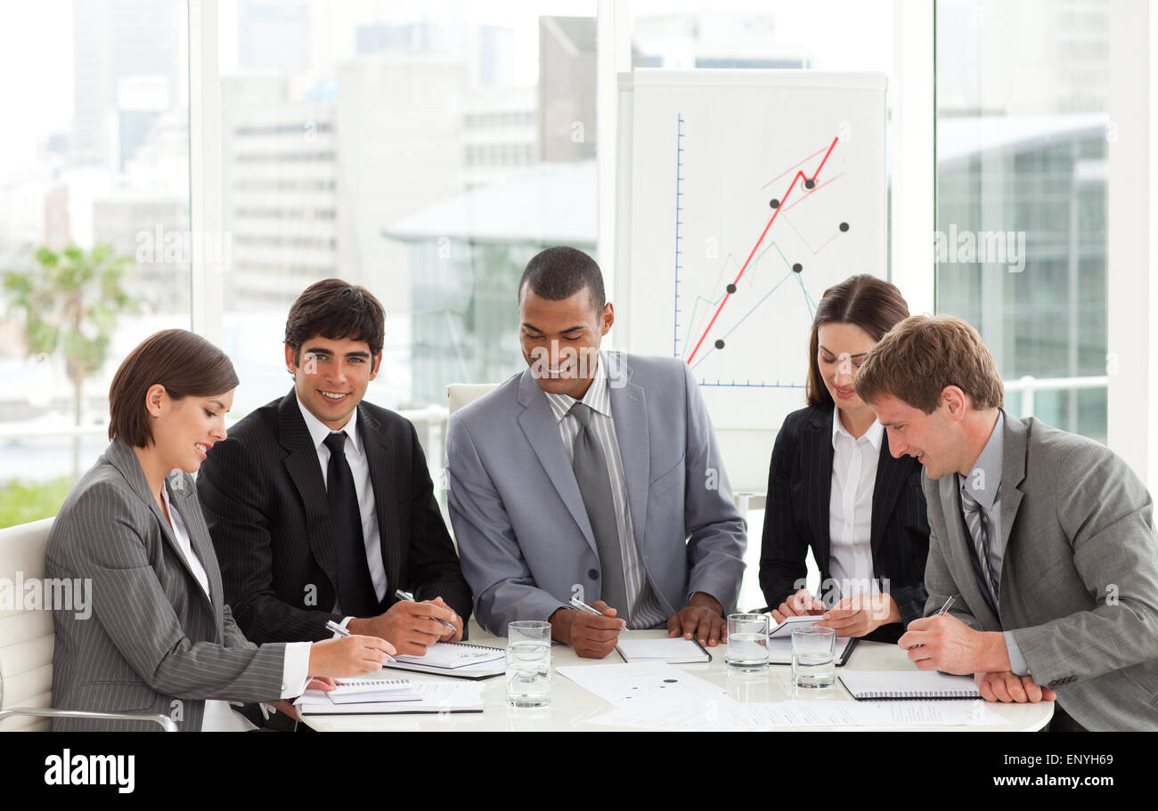 Multi-ethnic business team sitting around a conference table Stock ...