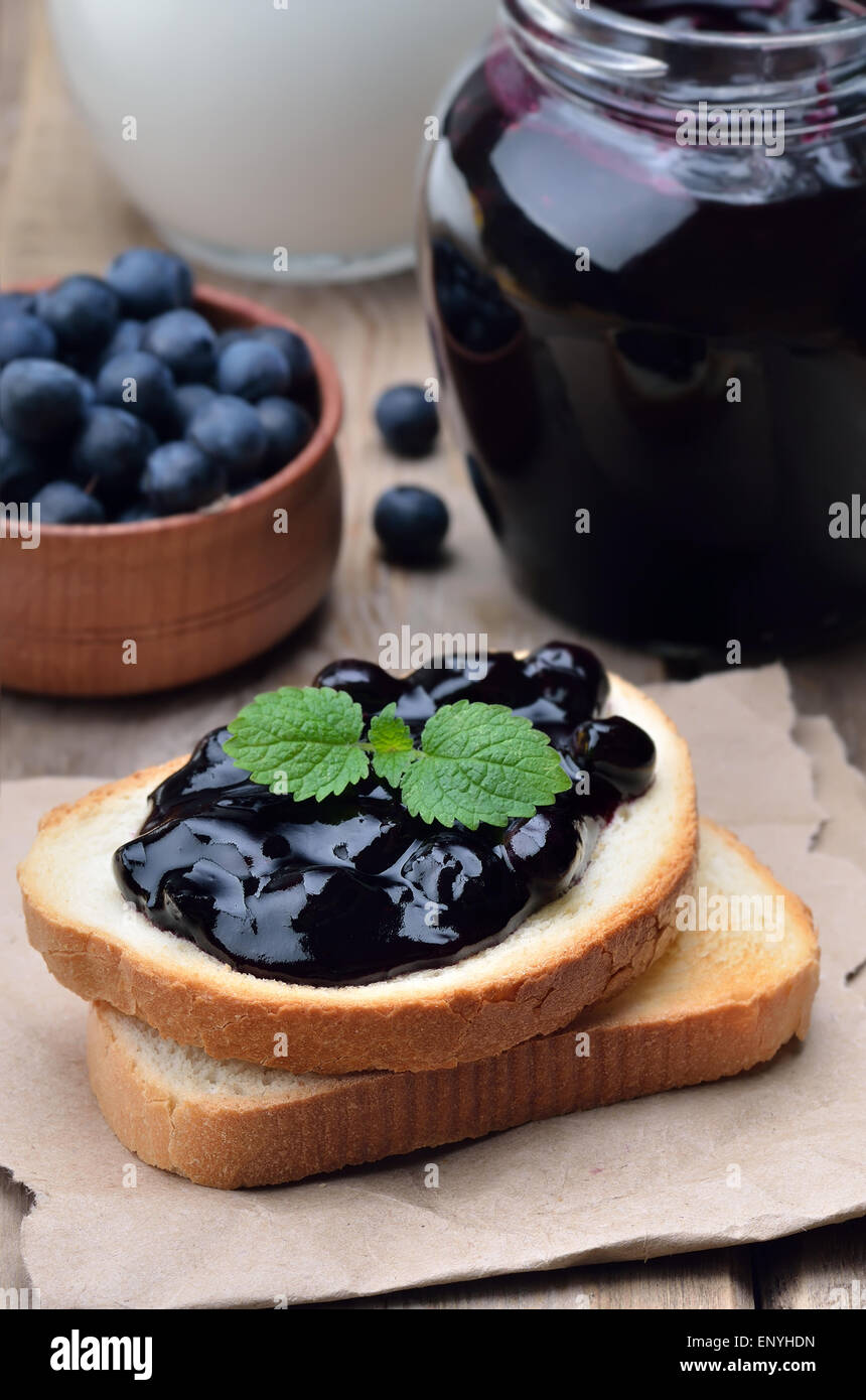 Bread with blueberry jam and jam in glass jar on wooden table Stock ...