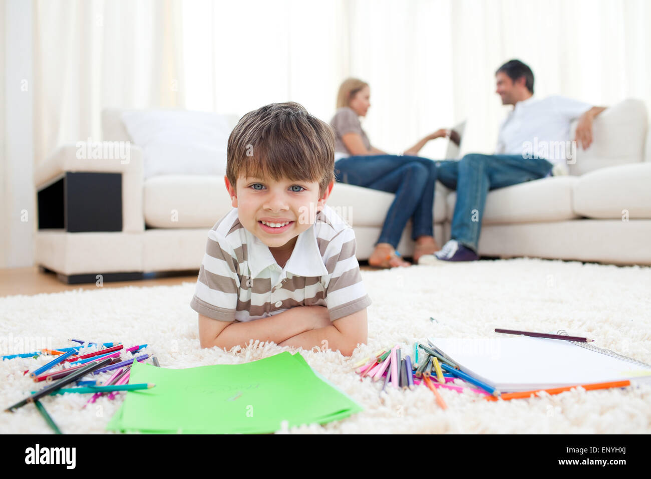 Smiling child drawing lying on the floor Stock Photo - Alamy
