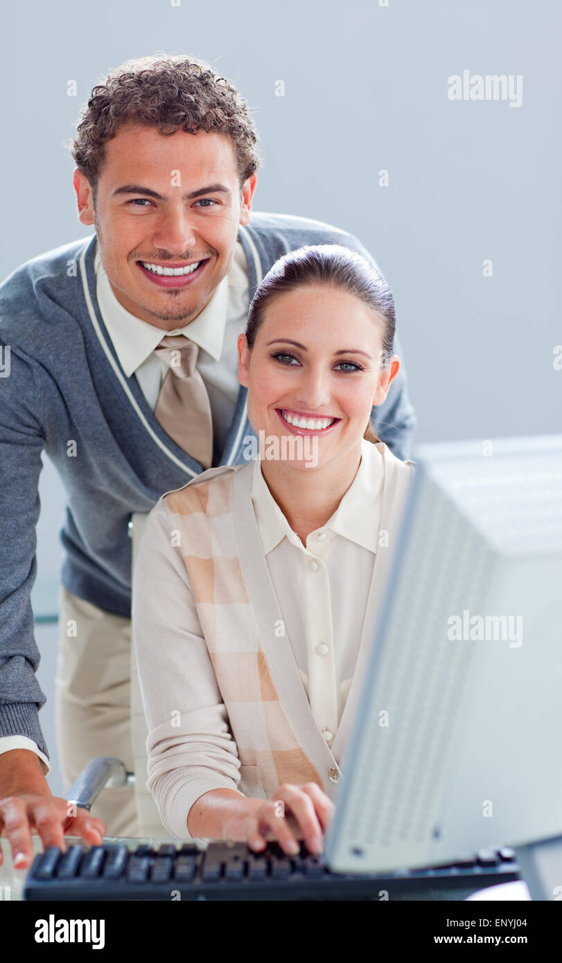 Handsome businessman helping his colleague work at a computer Stock ...