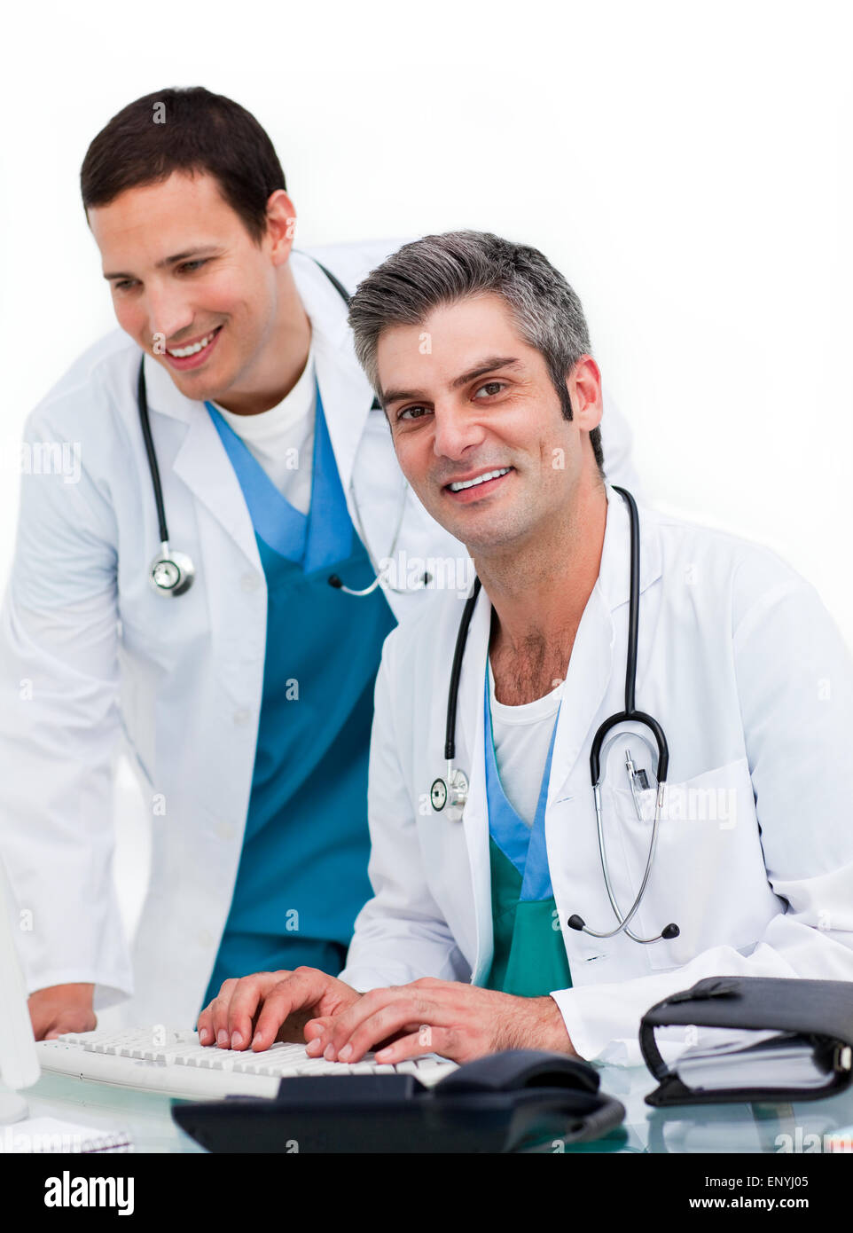 Two male doctors working at a computer against a white background Stock ...