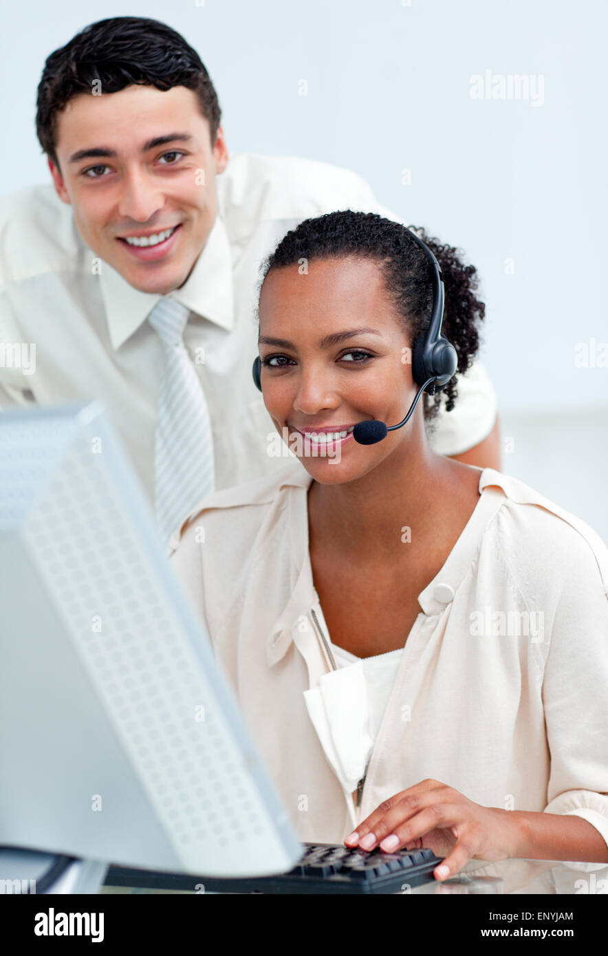 Young businessman helping his colleague at a computer Stock Photo - Alamy