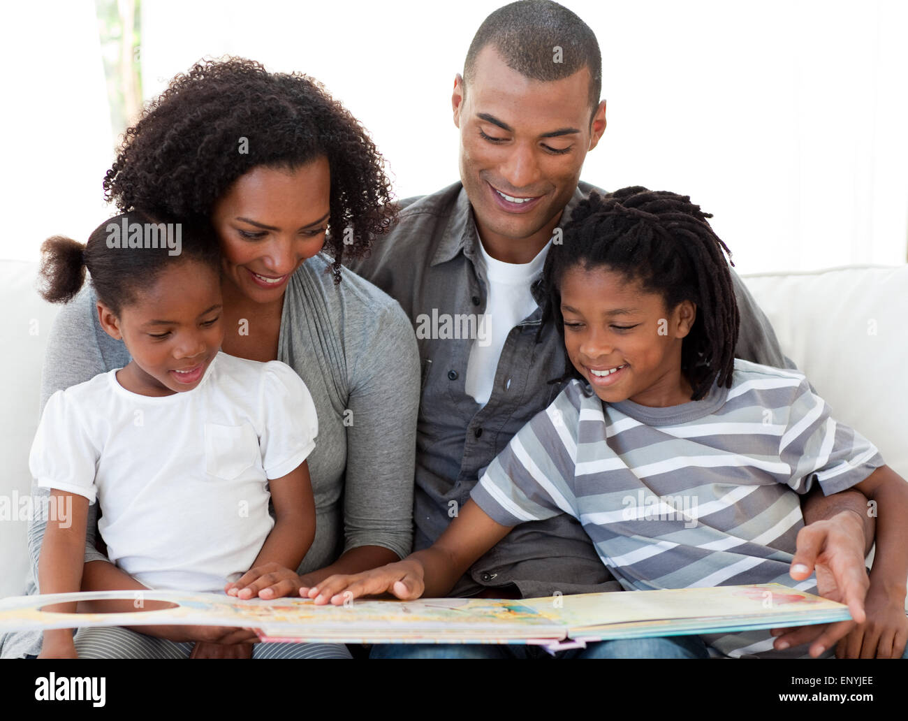 Afro-American family reading a book in the living-room Stock Photo - Alamy