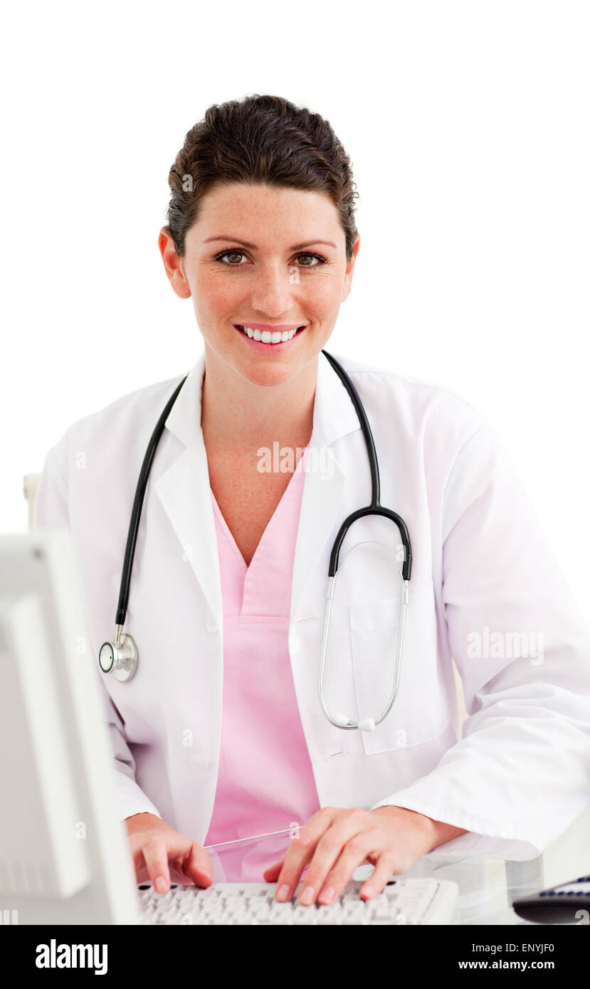 Charming female doctor working at a computer against a white background ...