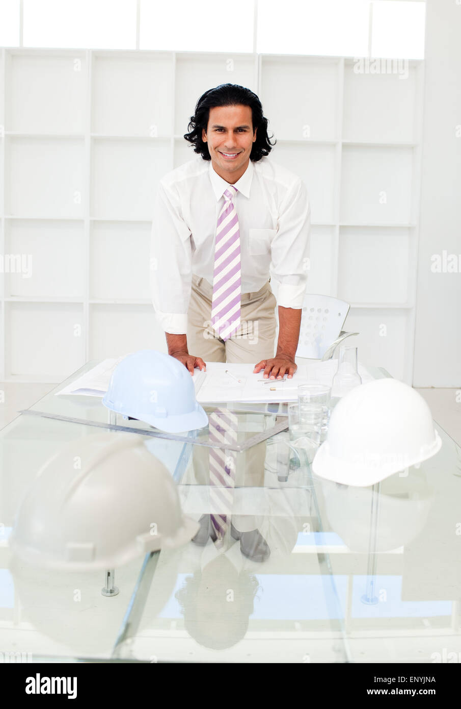 Attractive male engineer studying blueprints Stock Photo - Alamy