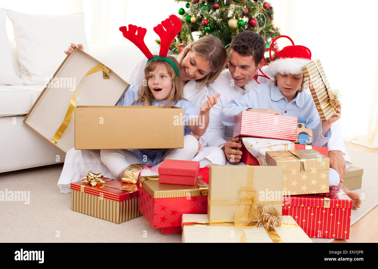 Portrait of a happy family unpacking Christmas presents Stock Photo - Alamy